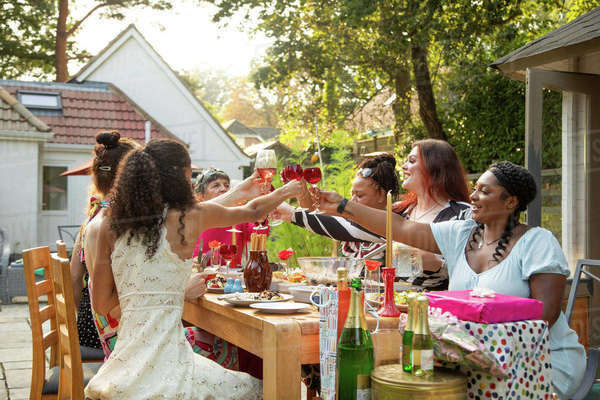 A mixed gathering of women laughing and having fun at a summer garden ...