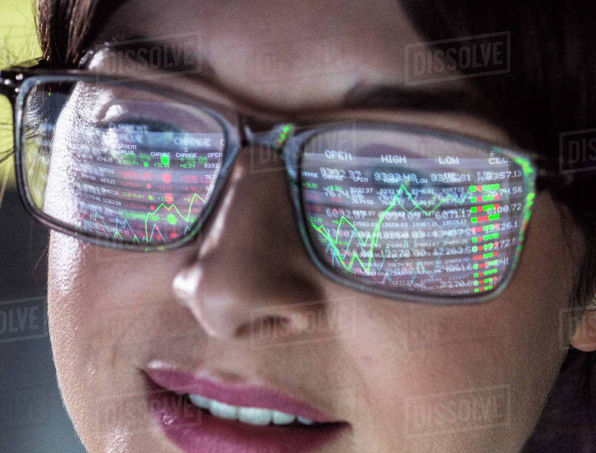 A focused individual wearing glasses with computer code reflection in ...