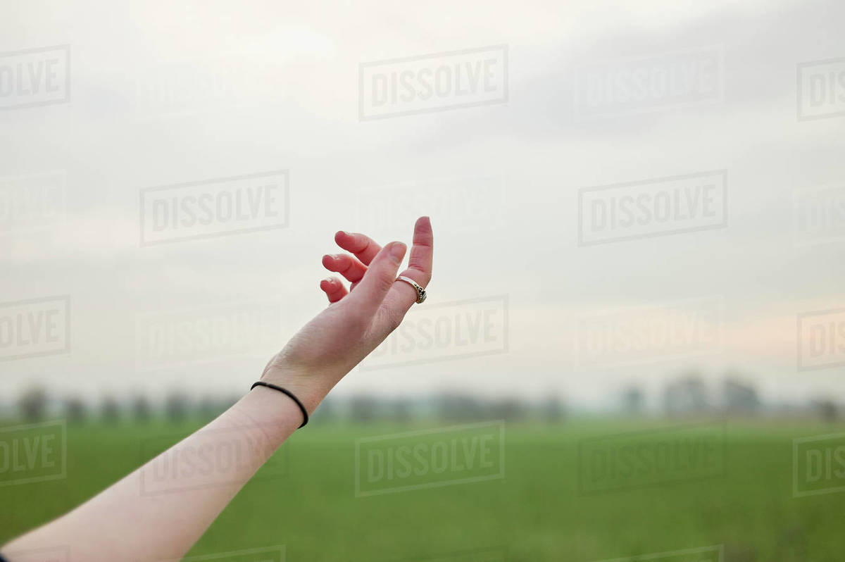 An outstretched arm reaching towards the sky with an open hand against ...