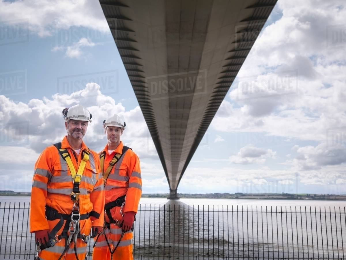 Portrait of bridge workers under suspension bridge. The Humber Bridge ...
