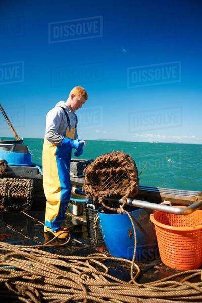 Fisherman at work on boat - Stock Photo - Dissolve