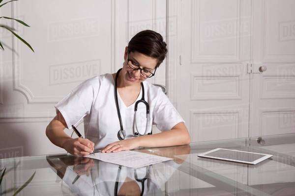 Doctor taking notes in office - Royalty-free Stock Photo | Dissolve