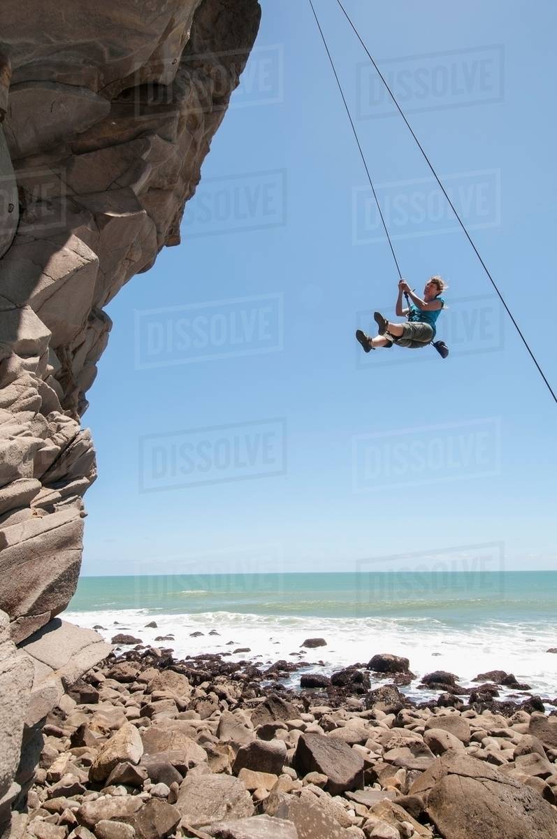Rock climber abseiling jagged cliff - Royalty-free Stock Photo | Dissolve