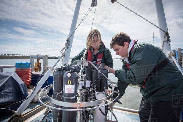 Scientists assembling sea water sampling experiment on research ship ...