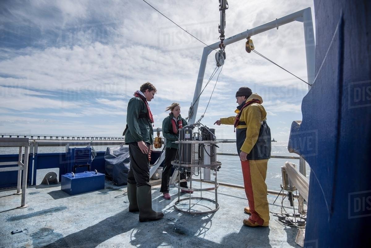 Scientists assembling sea water sampling experiment on research ship ...