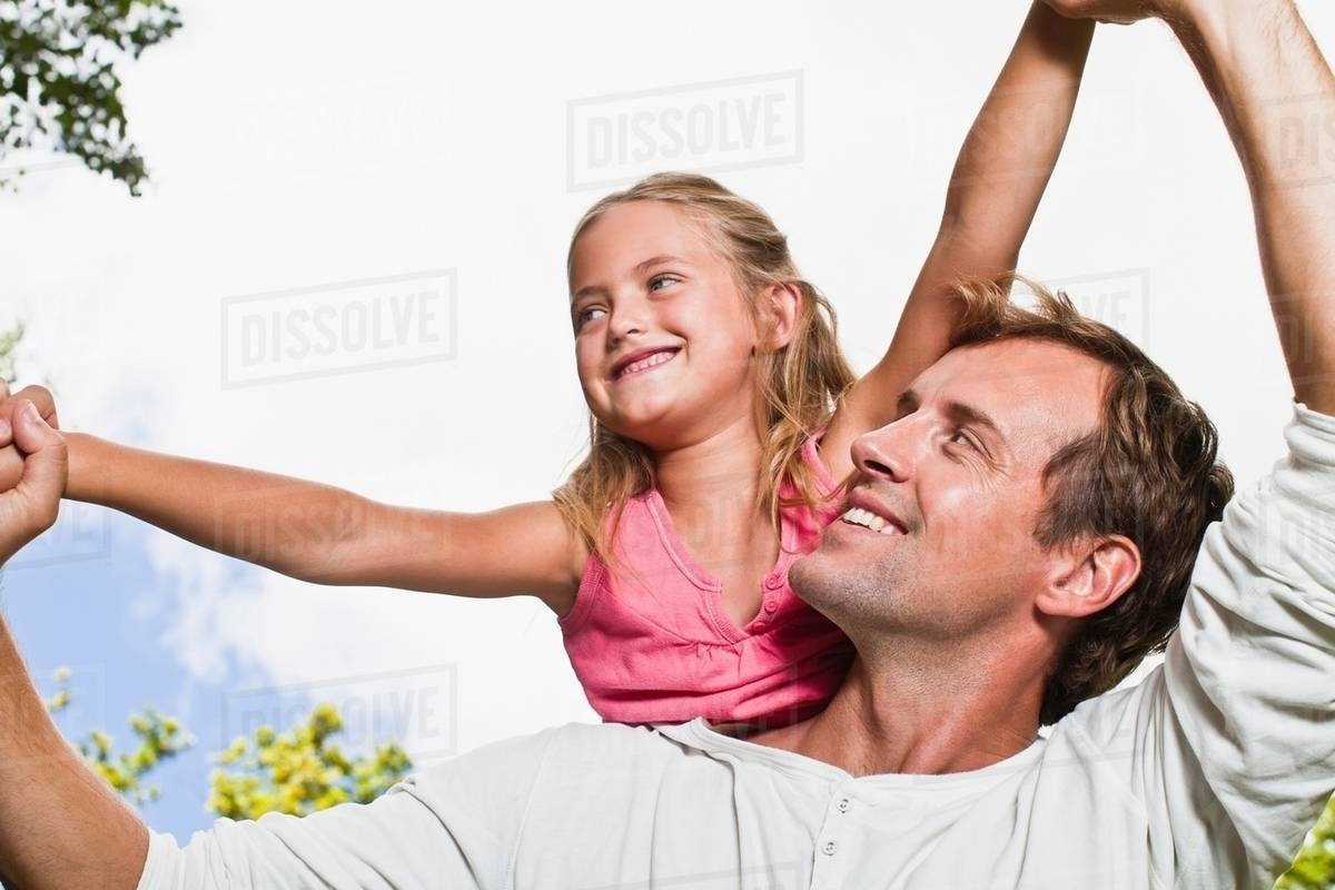 Father carrying daughter in park - Royalty-free Stock Photo | Dissolve