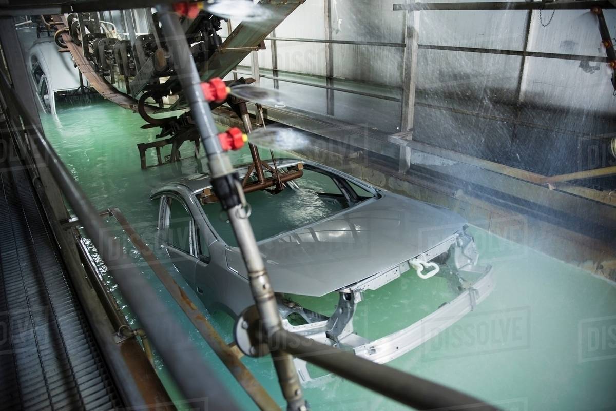 Car bodies being dipped in car factory - Stock Photo - Dissolve