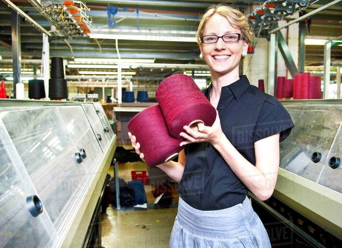 Worker with spools of thread in factory - Stock Photo - Dissolve