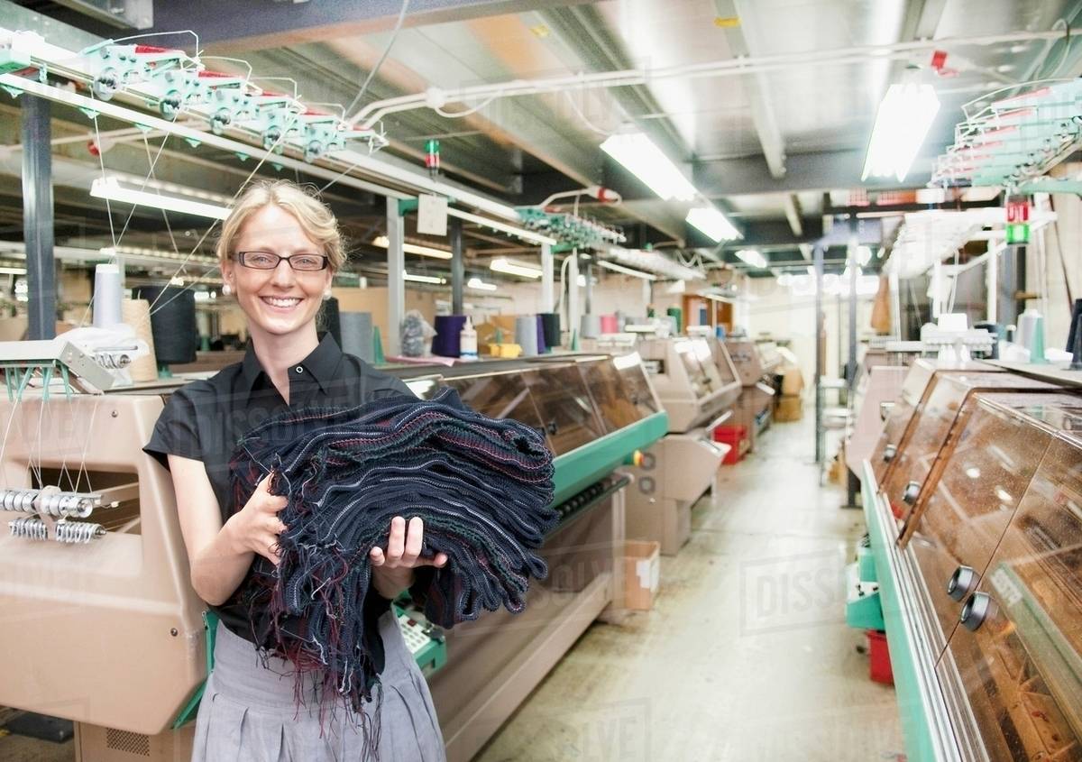 Worker with fabric in garment factory - Stock Photo - Dissolve