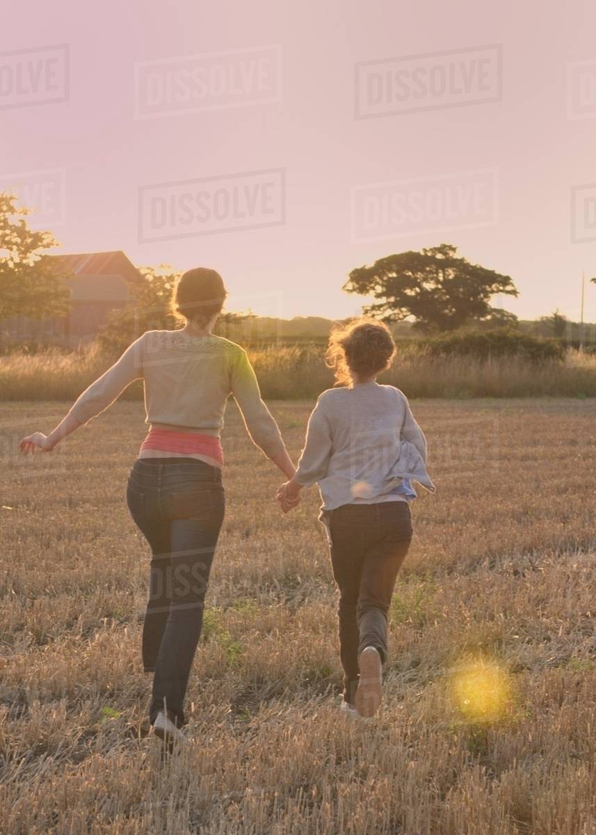 Mother and daughter running in field - Stock Photo - Dissolve