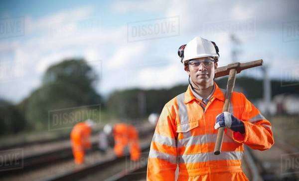 Railway worker holding tool - Stock Photo - Dissolve