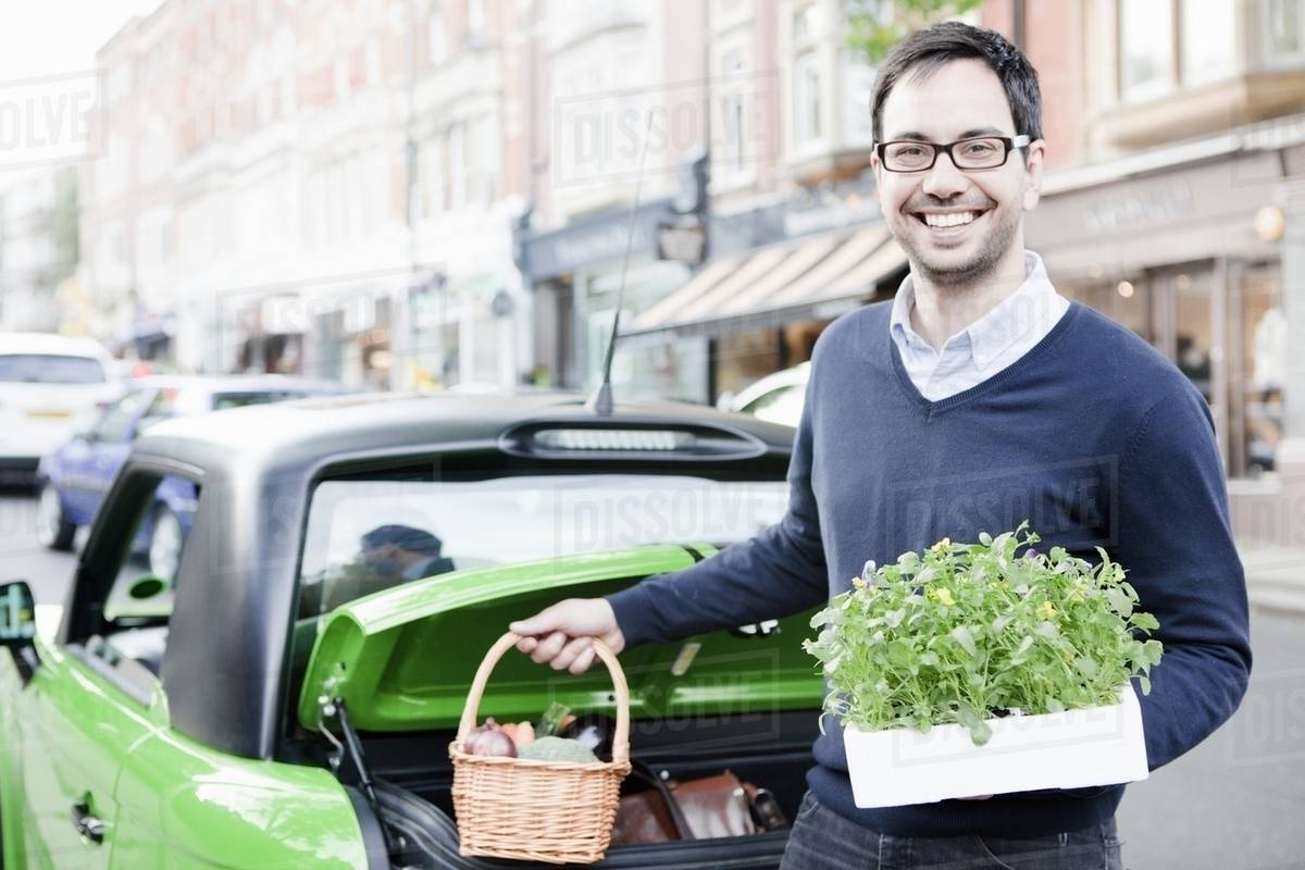 Man loading produce into car - Royalty-free Stock Photo | Dissolve