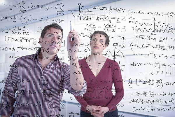 Mathematicians writing complex scientific equations on screen - Stock ...