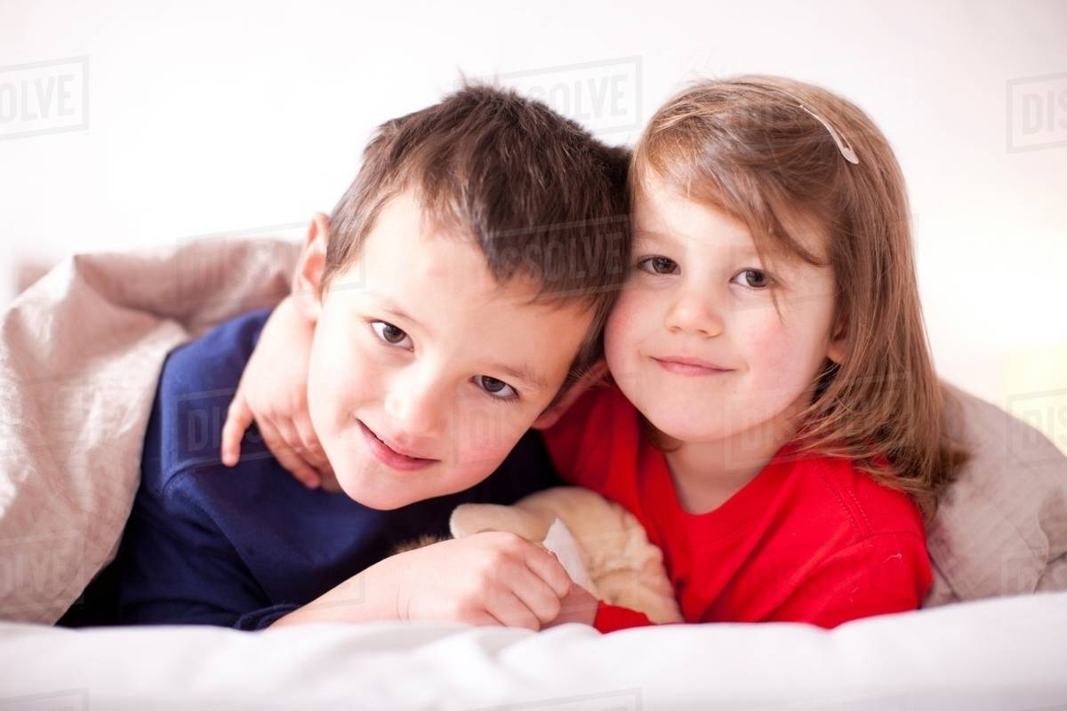 Two young children hugging under duvet - Royalty-free Stock Photo ...