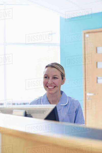Nurse sitting at reception desk - Stock Photo - Dissolve