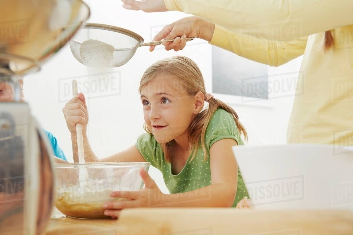 Children baking, sieving flour into mixing bowl - Royalty-free Stock ...
