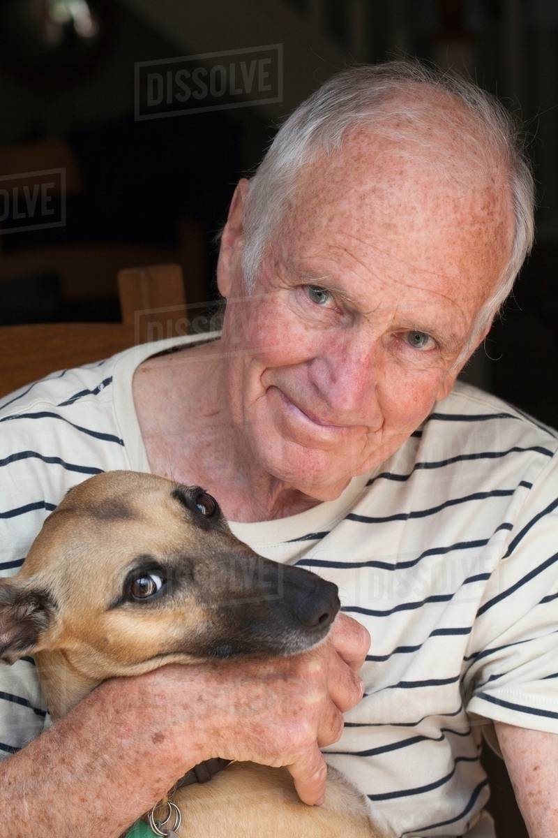 Senior man holding dog - Stock Photo - Dissolve