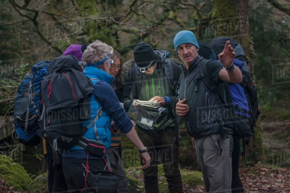 Group of people in forest with map - Royalty-free Stock Photo | Dissolve