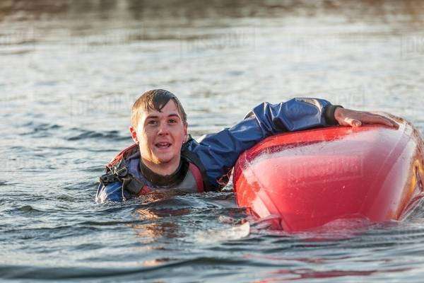 Young man falling in water with kayak - Royalty-free Stock Photo | Dissolve