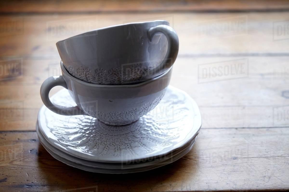 Cups and saucers on wooden table - Royalty-free Stock Photo | Dissolve