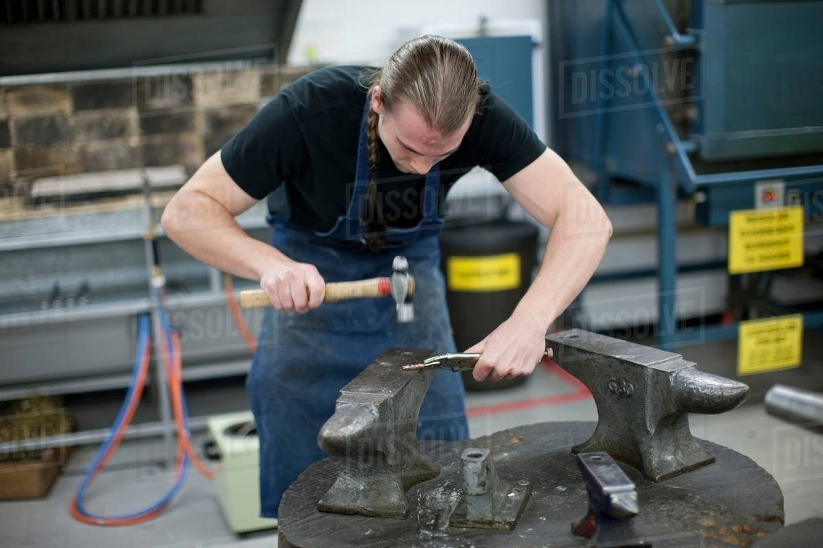 Man using hammer for metalworking in creative studio - Royalty-free ...