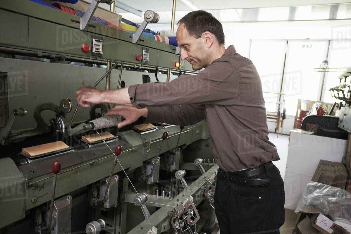 Worker using machine in wool factory - Royalty-free Stock Photo | Dissolve