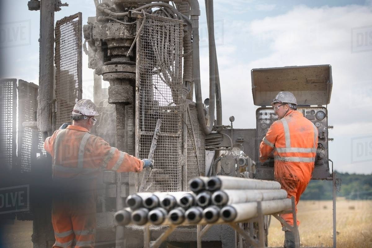 Drilling rig workers operating machinery - Stock Photo - Dissolve