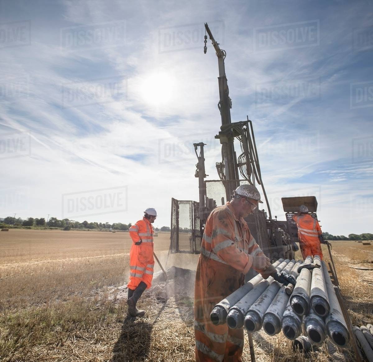 Workers operating drilling rig in field - Stock Photo - Dissolve