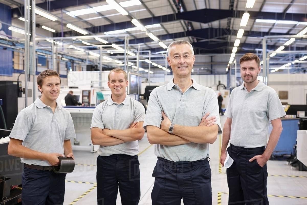 Portrait of manager and workers in engineering factory - Royalty-free ...