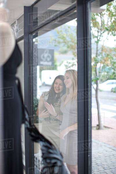 Friends window shopping, looking through shop front - Stock Photo ...