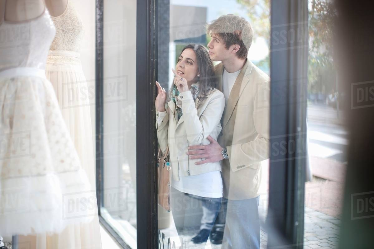 Young couple window shopping, looking through shop front - Stock Photo ...