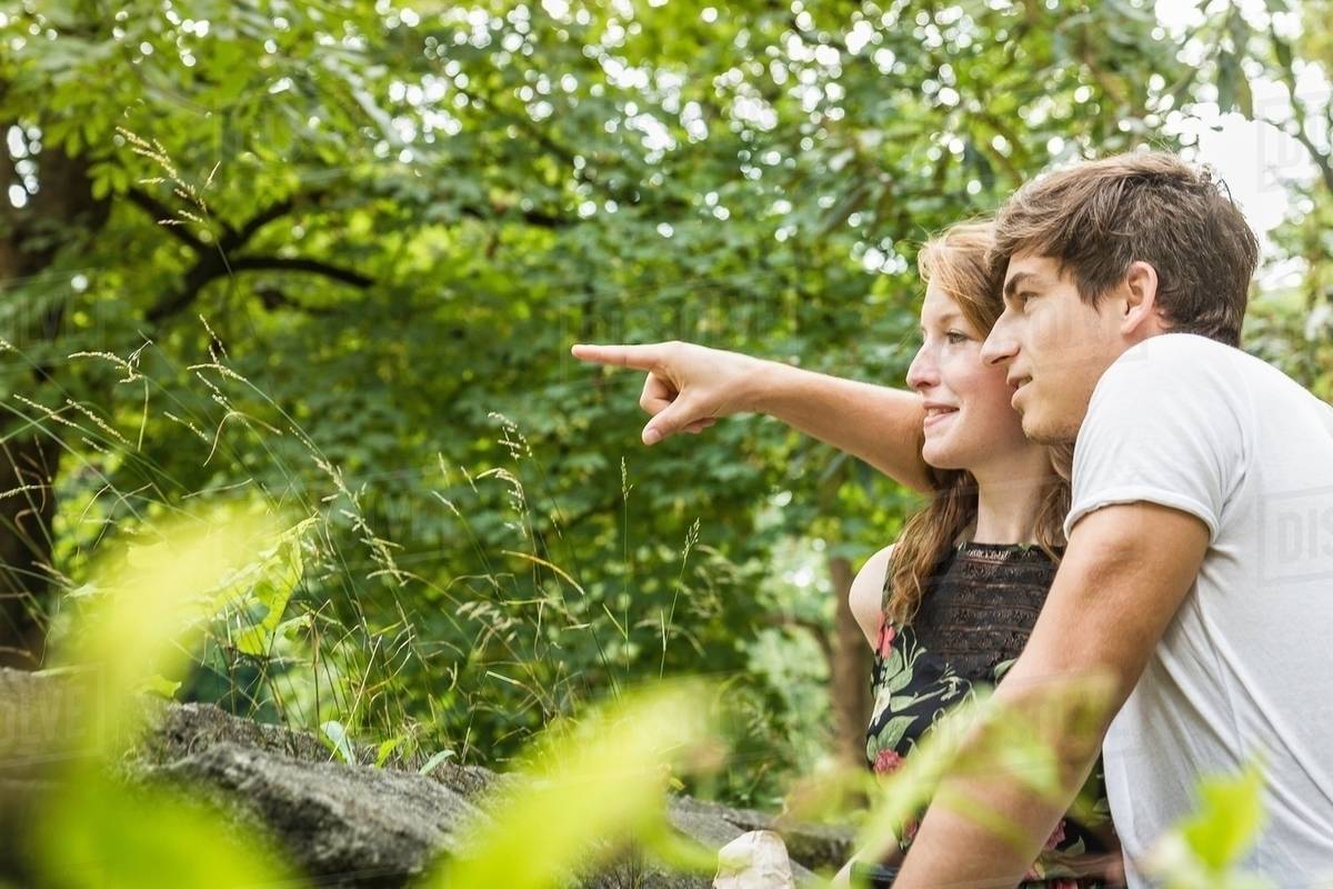 Couple in park, pointing finger - Royalty-free Stock Photo | Dissolve