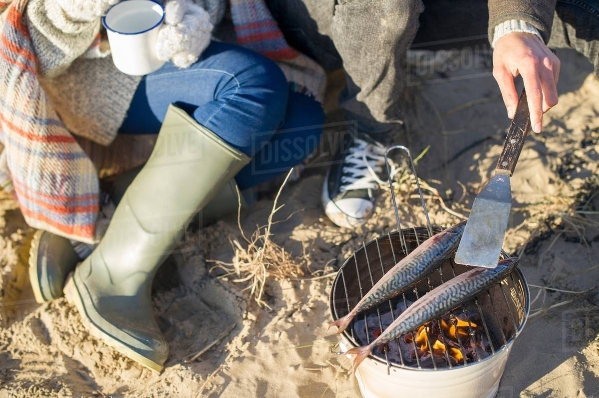 Cooking fish on the beach - Royalty-free Stock Photo | Dissolve