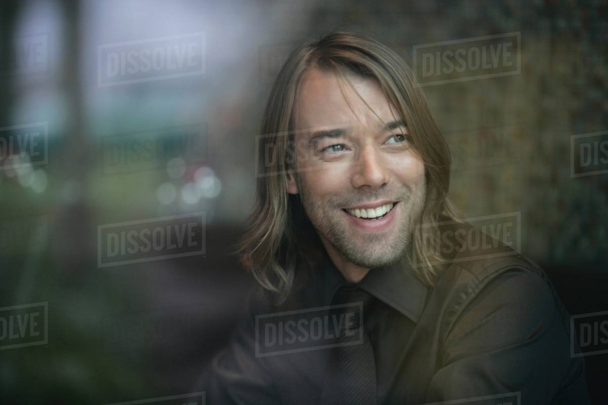 Businessman smiling through window - Stock Photo - Dissolve