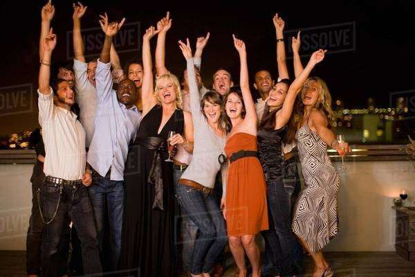 People cheering at party at night - Royalty-free Stock Photo | Dissolve