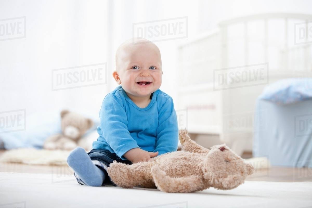 Baby boy playing with teddy bear - Royalty-free Stock Photo | Dissolve