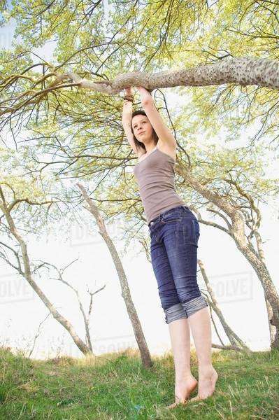 Girl climbing tree outdoors - Royalty-free Stock Photo | Dissolve