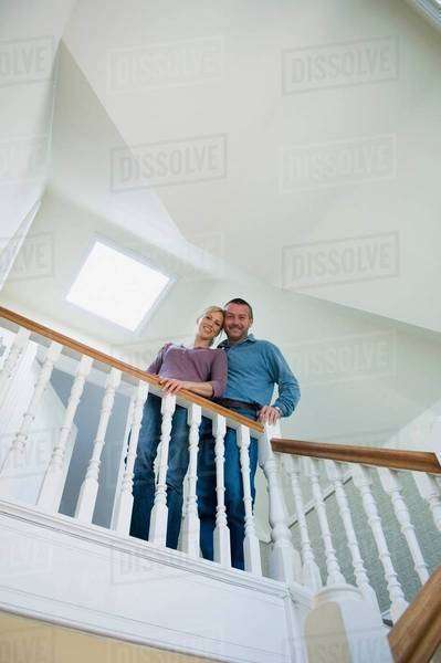 Smiling couple standing on stairs - Royalty-free Stock Photo | Dissolve