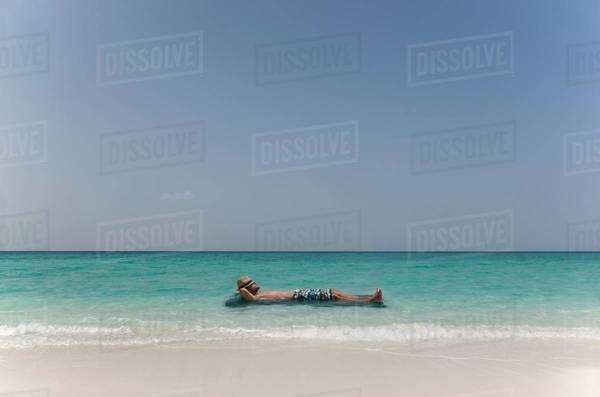 Man floating in water at tropical beach - Royalty-free Stock Photo ...