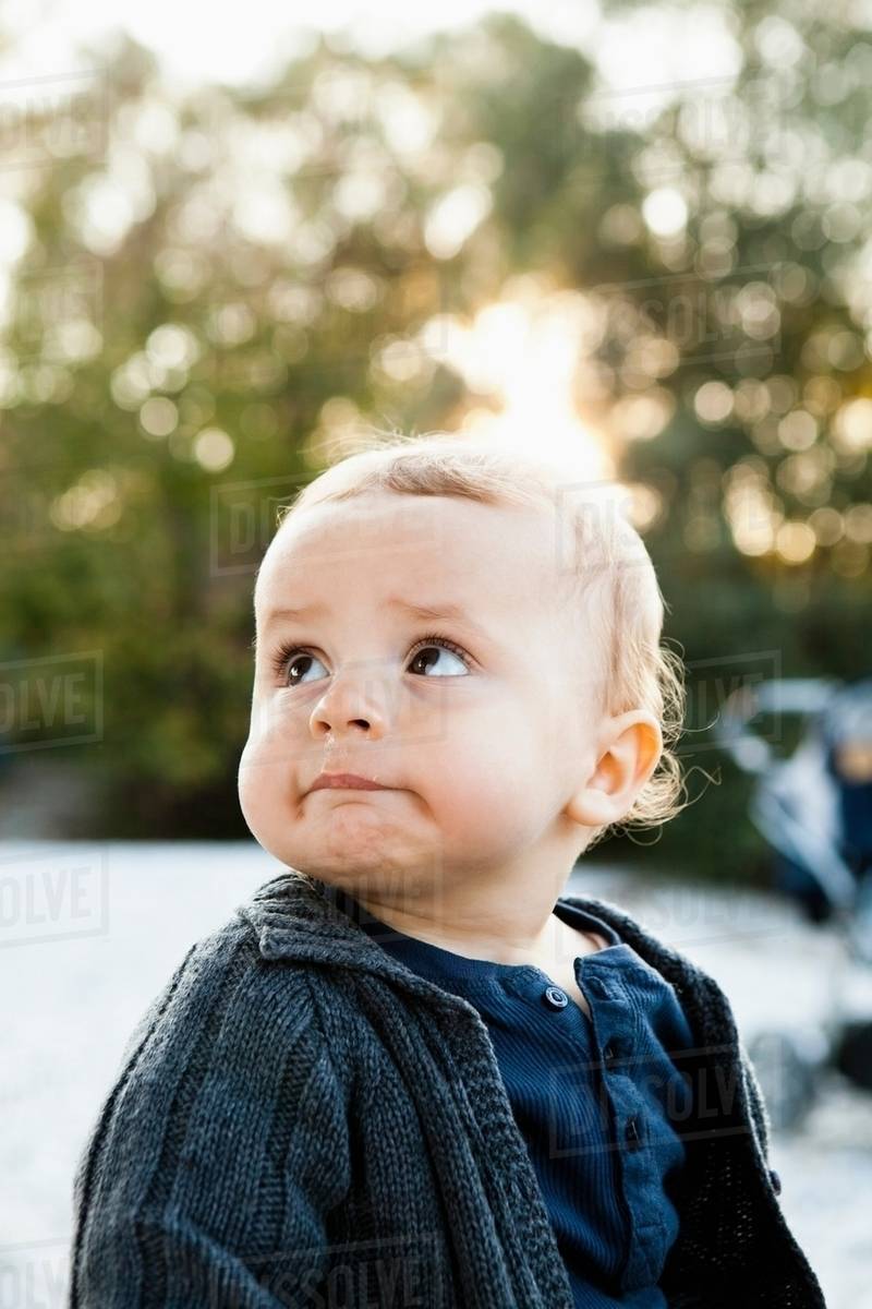 Scared baby sitting outdoors - Royalty-free Stock Photo | Dissolve