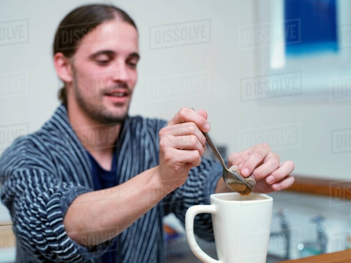 Man making cup of tea in kitchen - Royalty-free Stock Photo | Dissolve