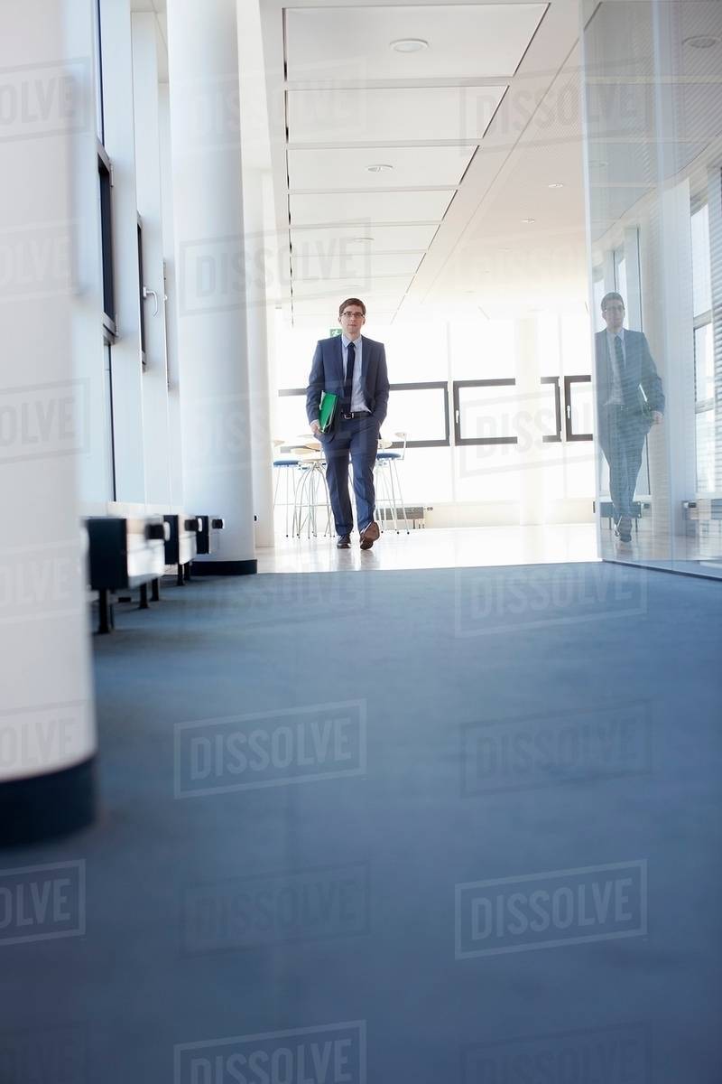 Businessman walking in empty office - Royalty-free Stock Photo | Dissolve