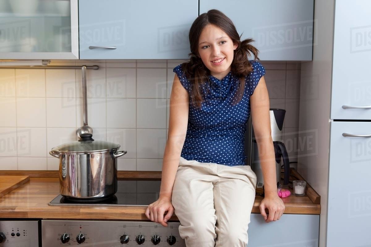 Smiling girl cooking in kitchen - Royalty-free Stock Photo | Dissolve