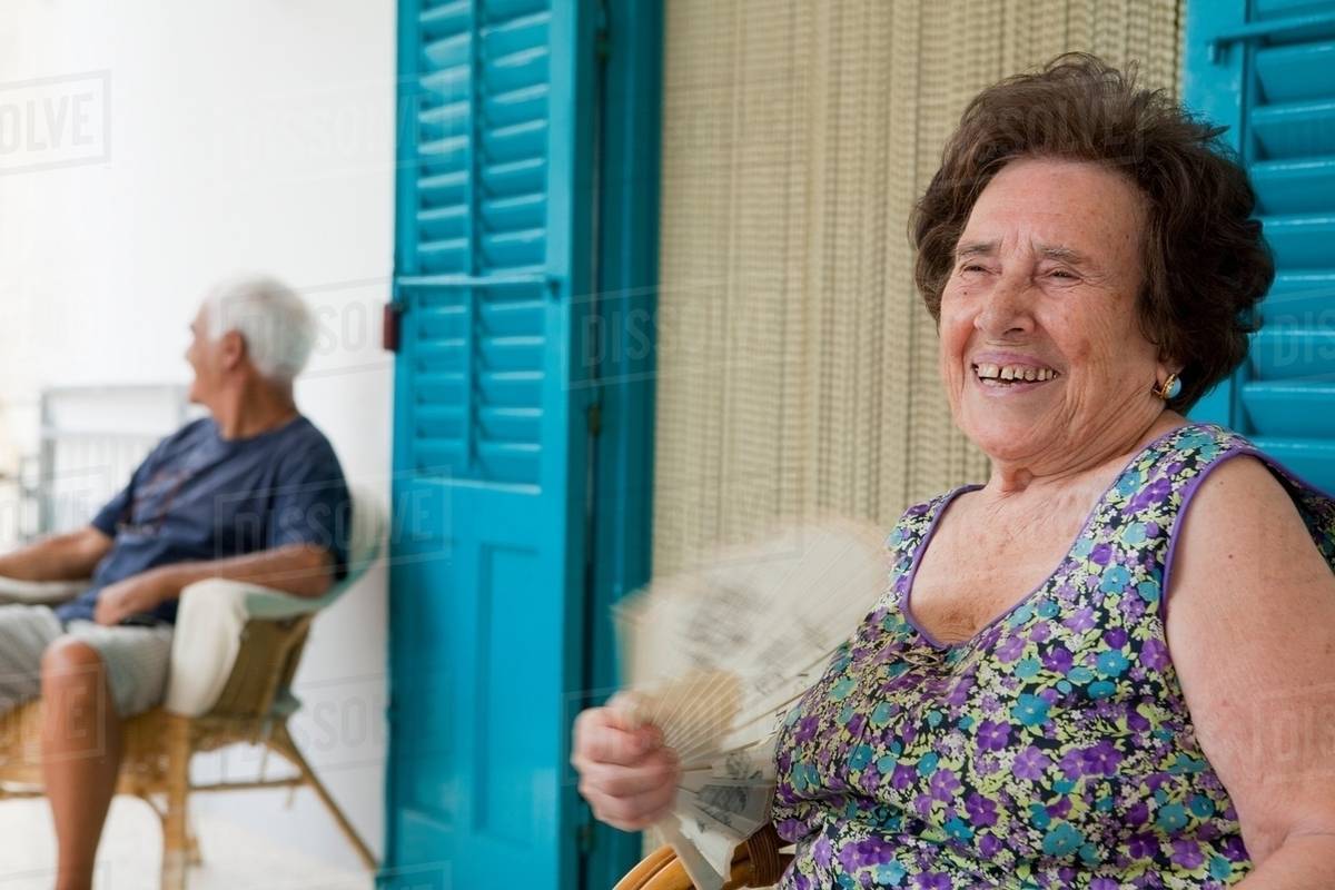 Older woman fanning herself outdoors - Stock Photo - Dissolve