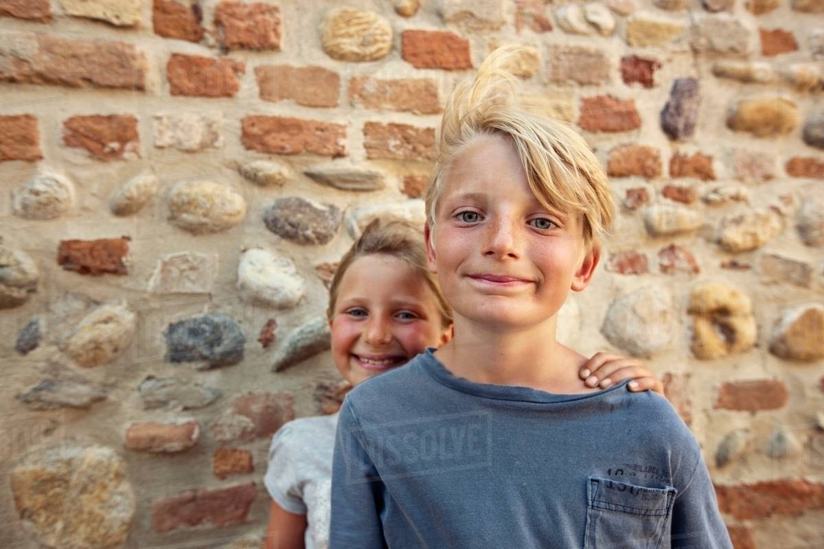 Siblings smiling together outdoors - Stock Photo - Dissolve