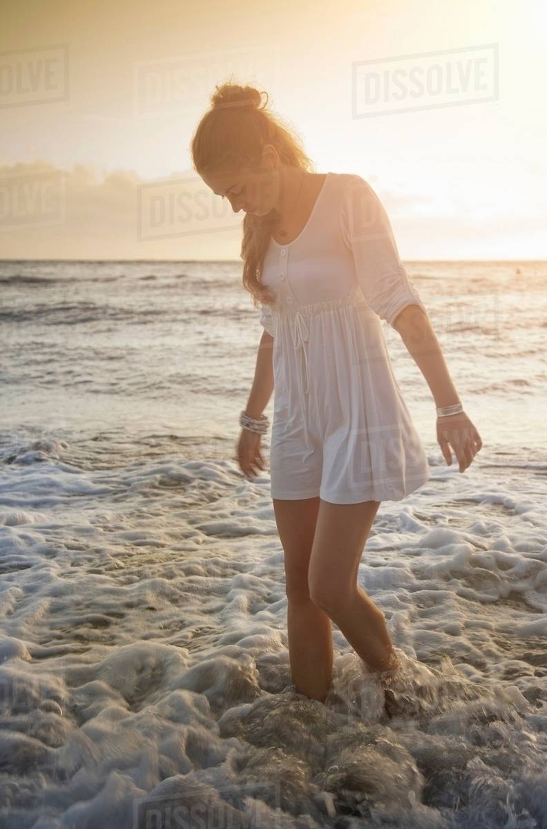 Woman walking in water at beach - Royalty-free Stock Photo | Dissolve
