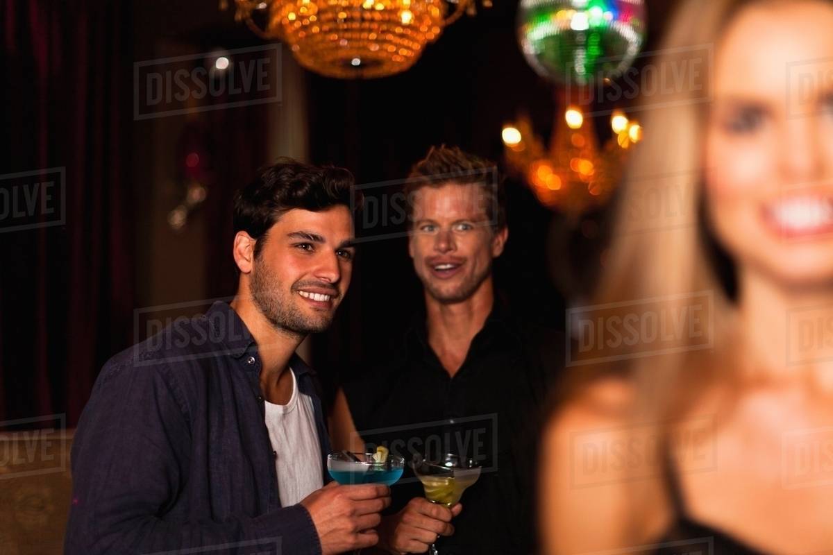 Smiling men having cocktails in club - Royalty-free Stock Photo | Dissolve