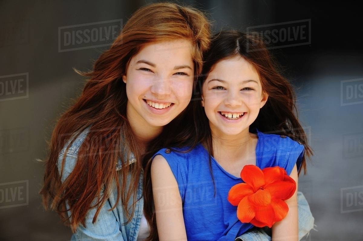 Sisters smiling together outdoors - Royalty-free Stock Photo | Dissolve