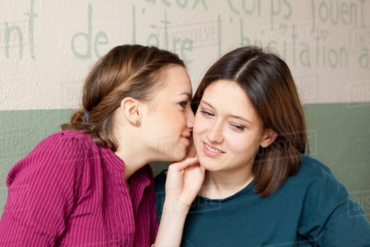Women whispering to each other - Stock Photo - Dissolve
