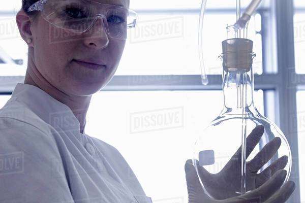 Scientist holding beaker in lab - Royalty-free Stock Photo | Dissolve